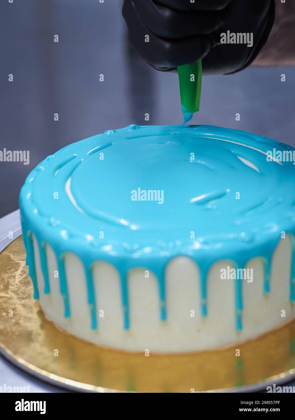 bag piping filling topping on frosted icing drip turquoise cake for ...