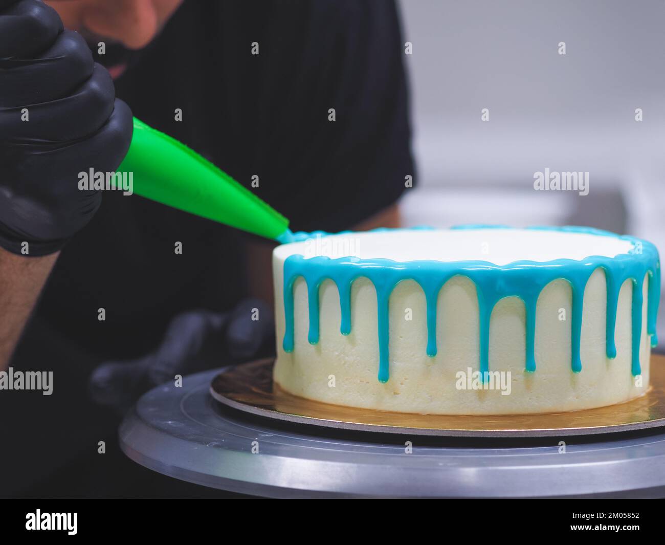 bag piping filling topping on frosted icing drip turquoise cake for ...