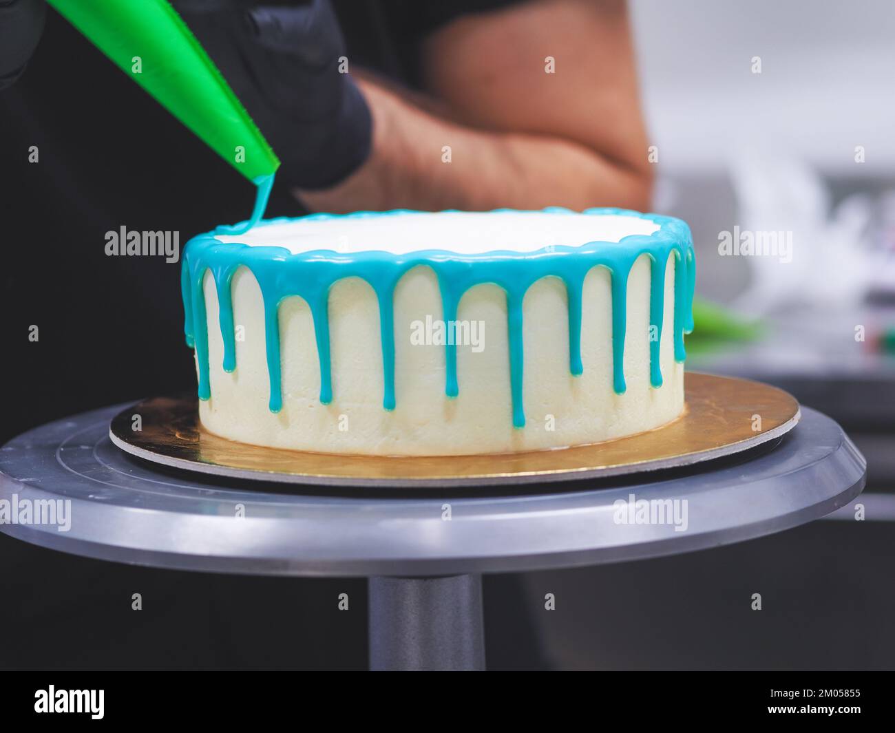bag piping filling topping on frosted icing drip turquoise cake for ...