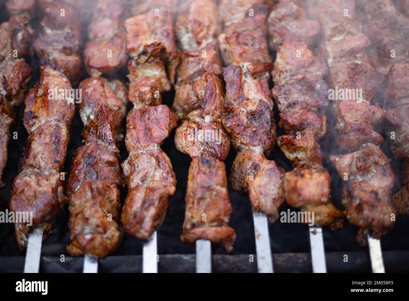 Fried kebab on a homemade grill, with smoke, shallow depth of field ...