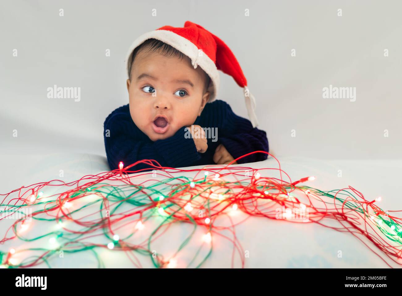 infant boy wearing Christmas red cap playing cute facial expression ...