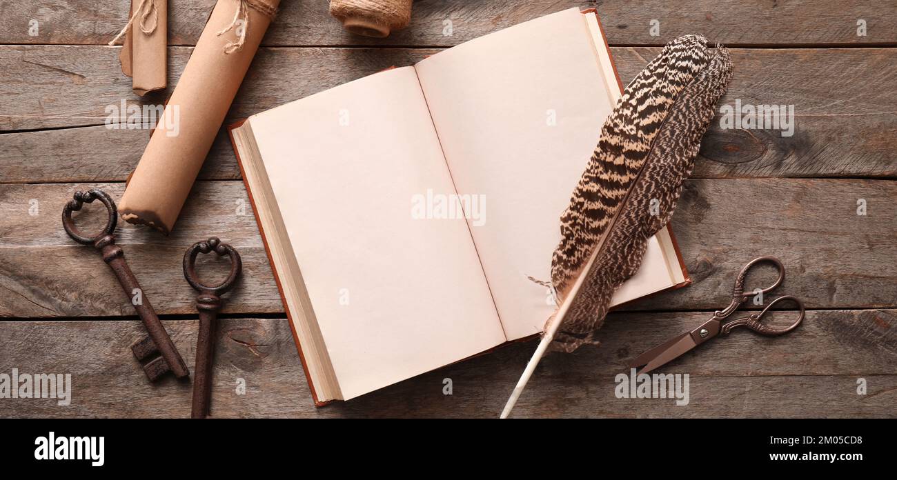Open old book, scrolls, feather and keys on wooden background Stock ...