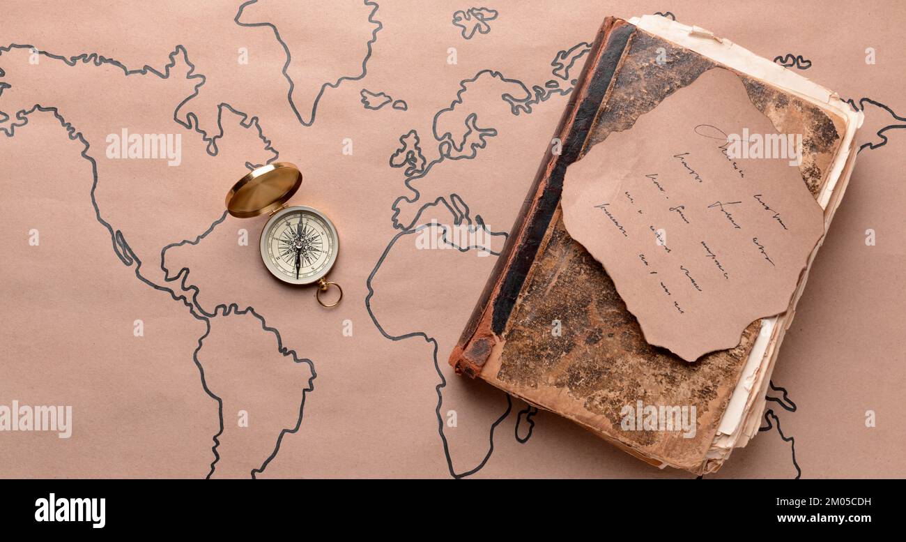 Old book, compass and paper sheet on world map. Travel concept Stock ...