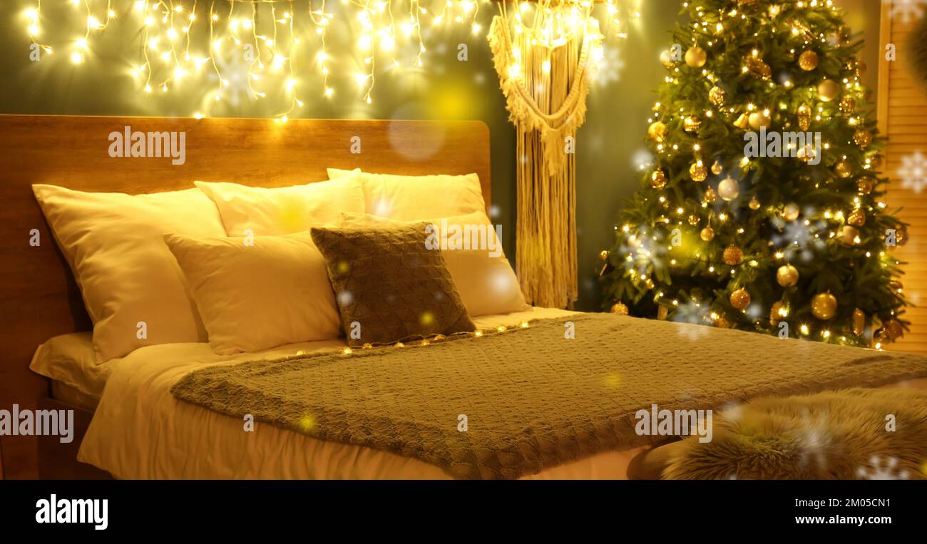 Interior of cozy bedroom with Christmas tree and glowing lights at ...
