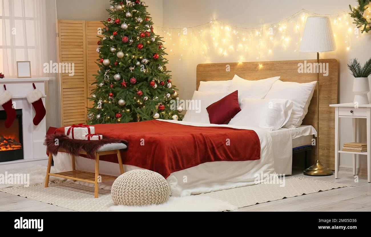 Interior of light bedroom with glowing lights and Christmas tree Stock ...