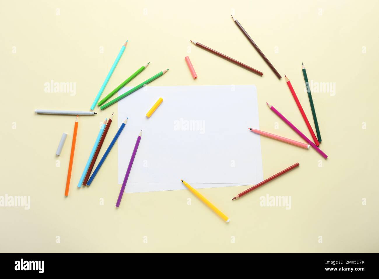 Blank paper sheet with pencils and felt-tip pens on beige background ...