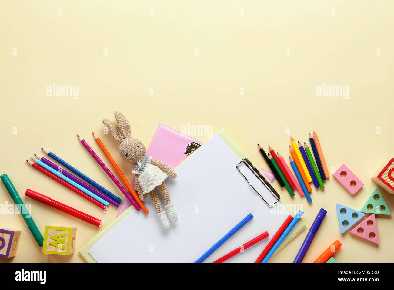 Clipboards with blank paper sheet, pencils, felt-tip pens and toy on ...
