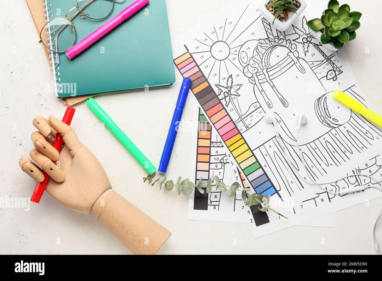 Coloring pages, felt-tip pens, wooden hand, notebooks and eyeglasses on ...