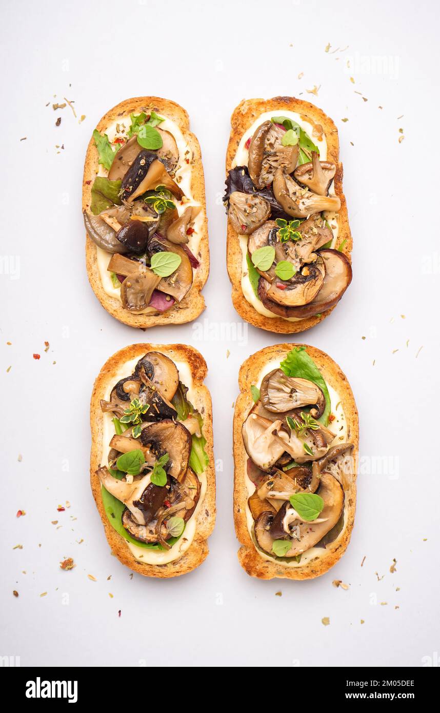Tasty toasts with cream cheese and mushrooms on white background Stock ...