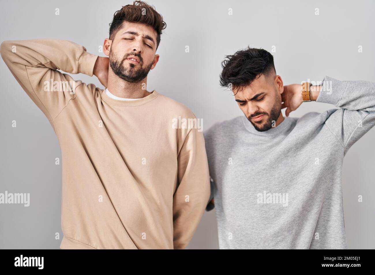 Young homosexual couple standing over white background suffering of ...