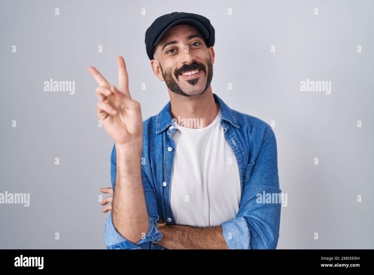 Hispanic man with beard standing over isolated background smiling with ...