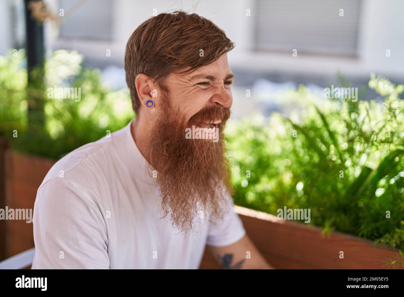 Young redhead man smiling confident sitting on table at coffee shop ...