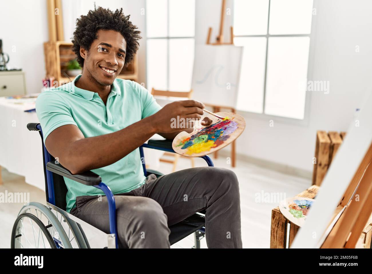Young african american disabled artist man sitting on wheelchair ...