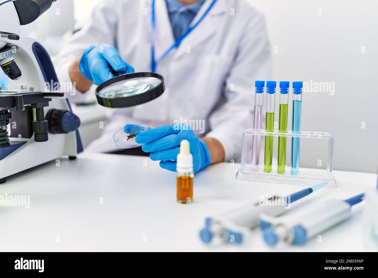 Young blond man scientist using magnifying glass at laboratory Stock ...