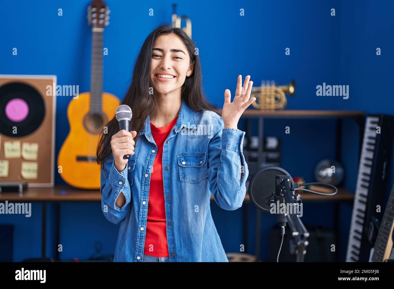 Young teenager girl singing song using microphone celebrating victory ...