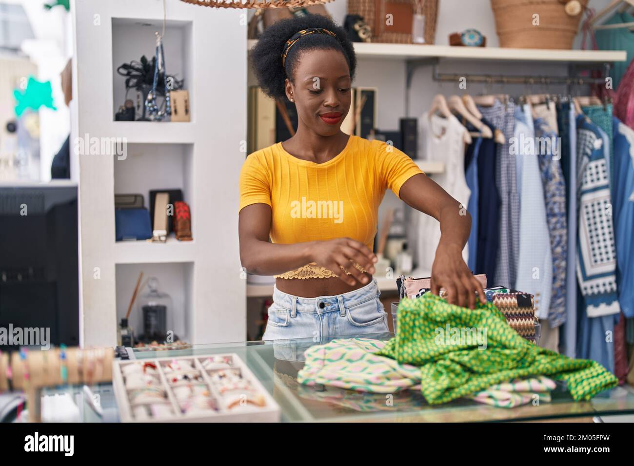 African american woman shop assistant folding clothes working at ...