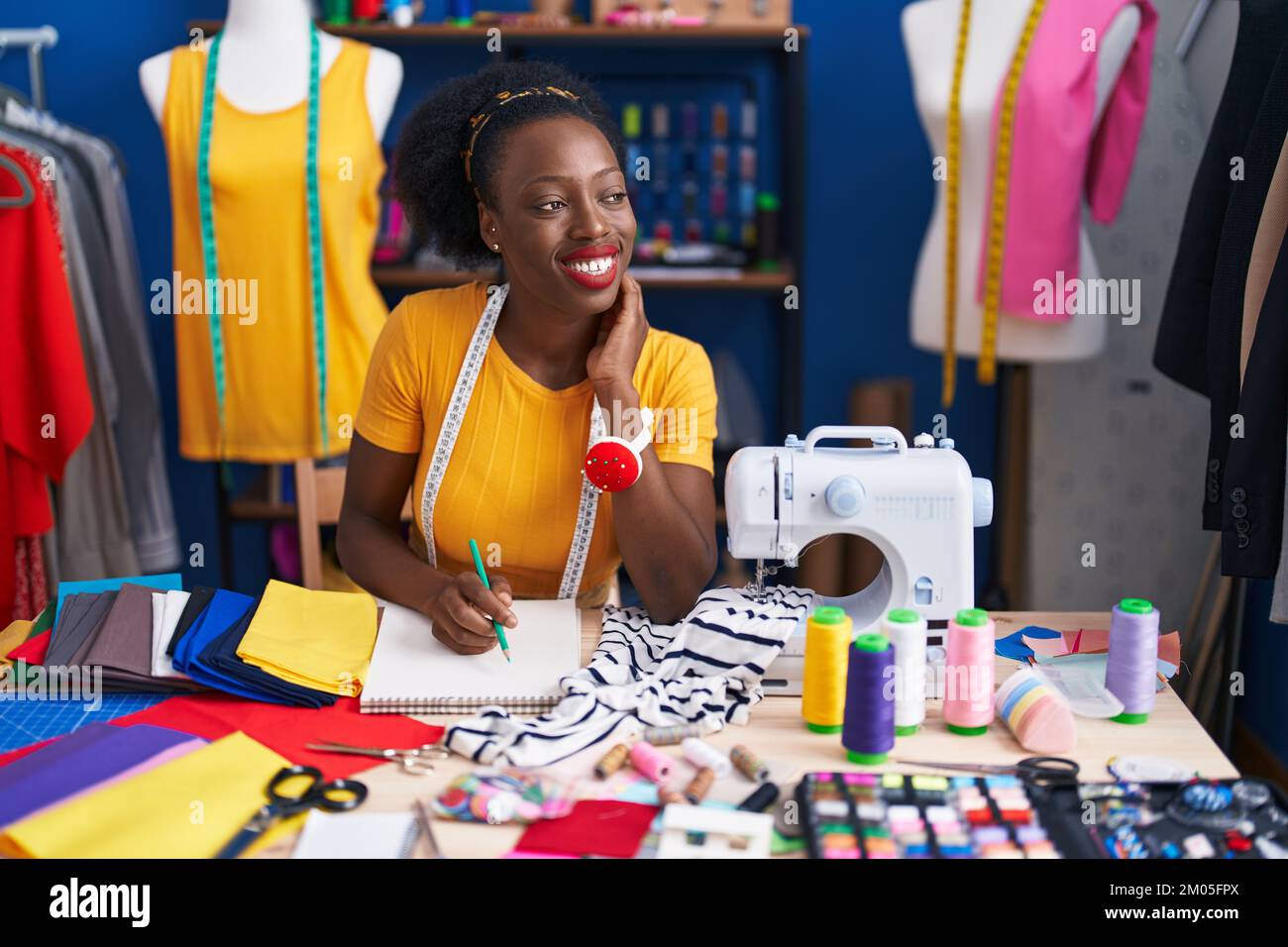 African american woman tailor smiling confident writing on notebook at ...