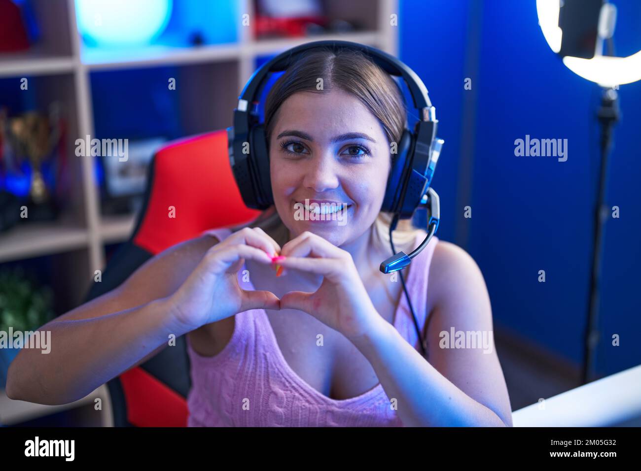 Young beautiful hispanic woman streamer smiling confident doing heart ...