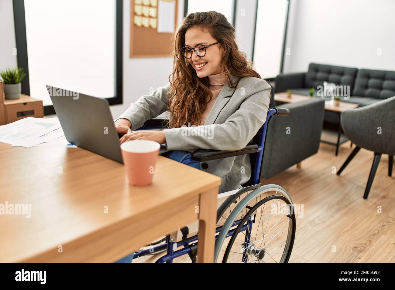 Young beautiful hispanic woman business worker using laptop sitting on ...