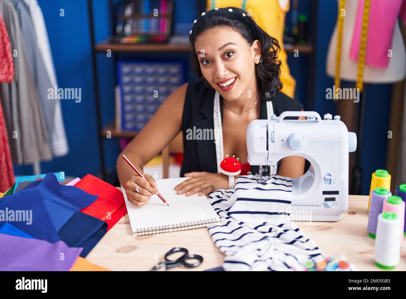 Young beautiful hispanic woman tailor smiling confident drawing on ...