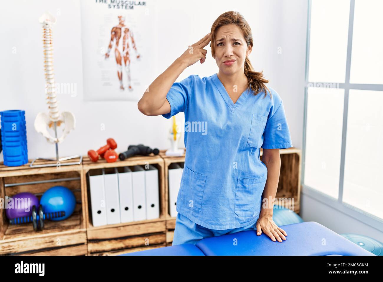 Middle age hispanic physiotherapist woman working at pain recovery ...