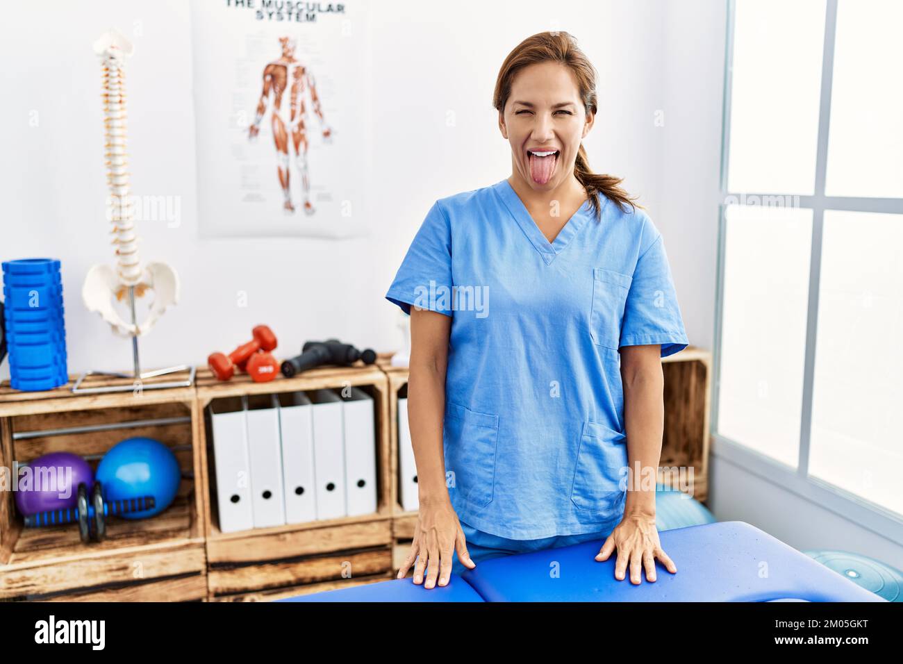 Middle age hispanic physiotherapist woman working at pain recovery ...