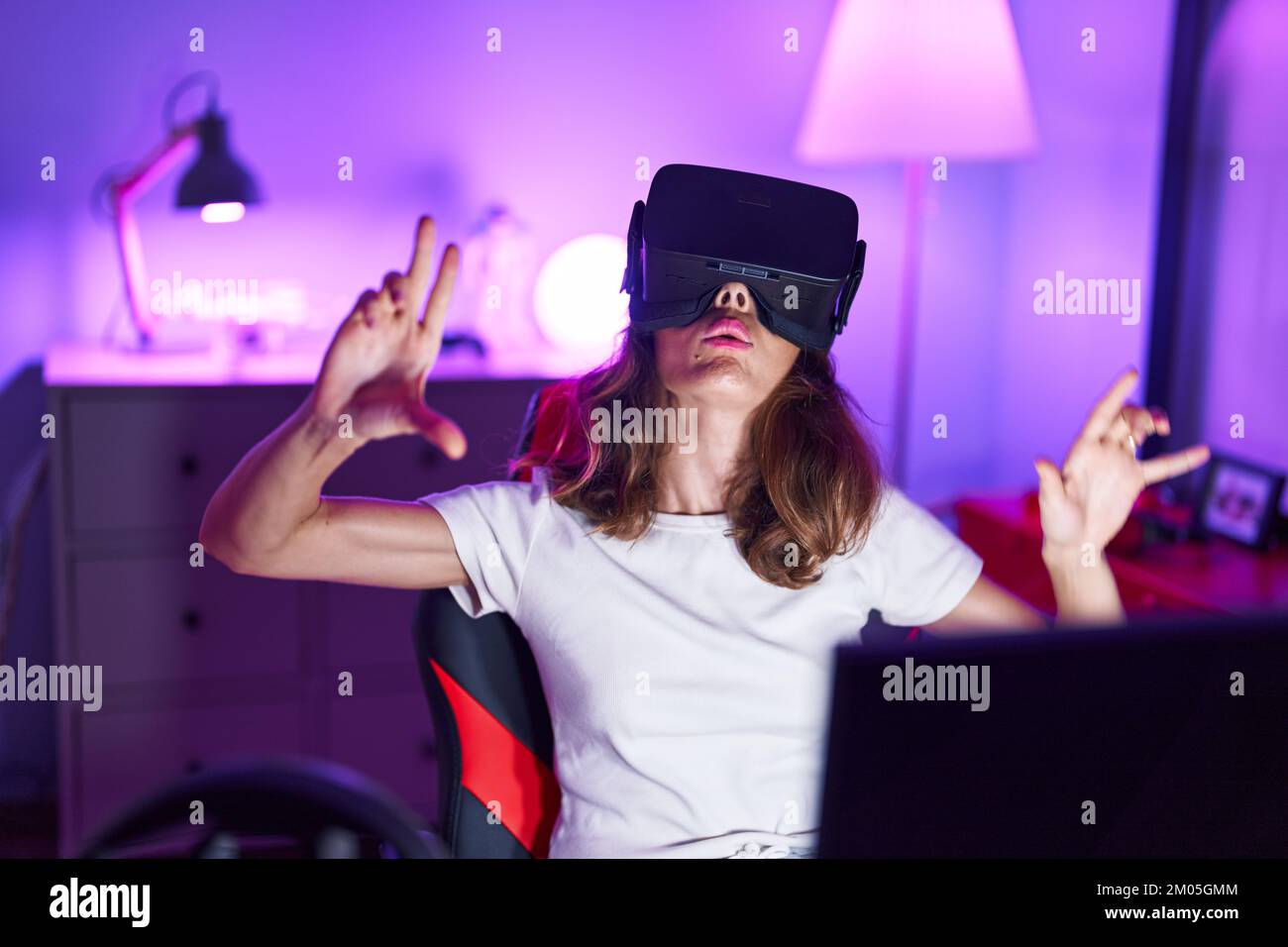 Young beautiful hispanic woman streamer playing video game using ...