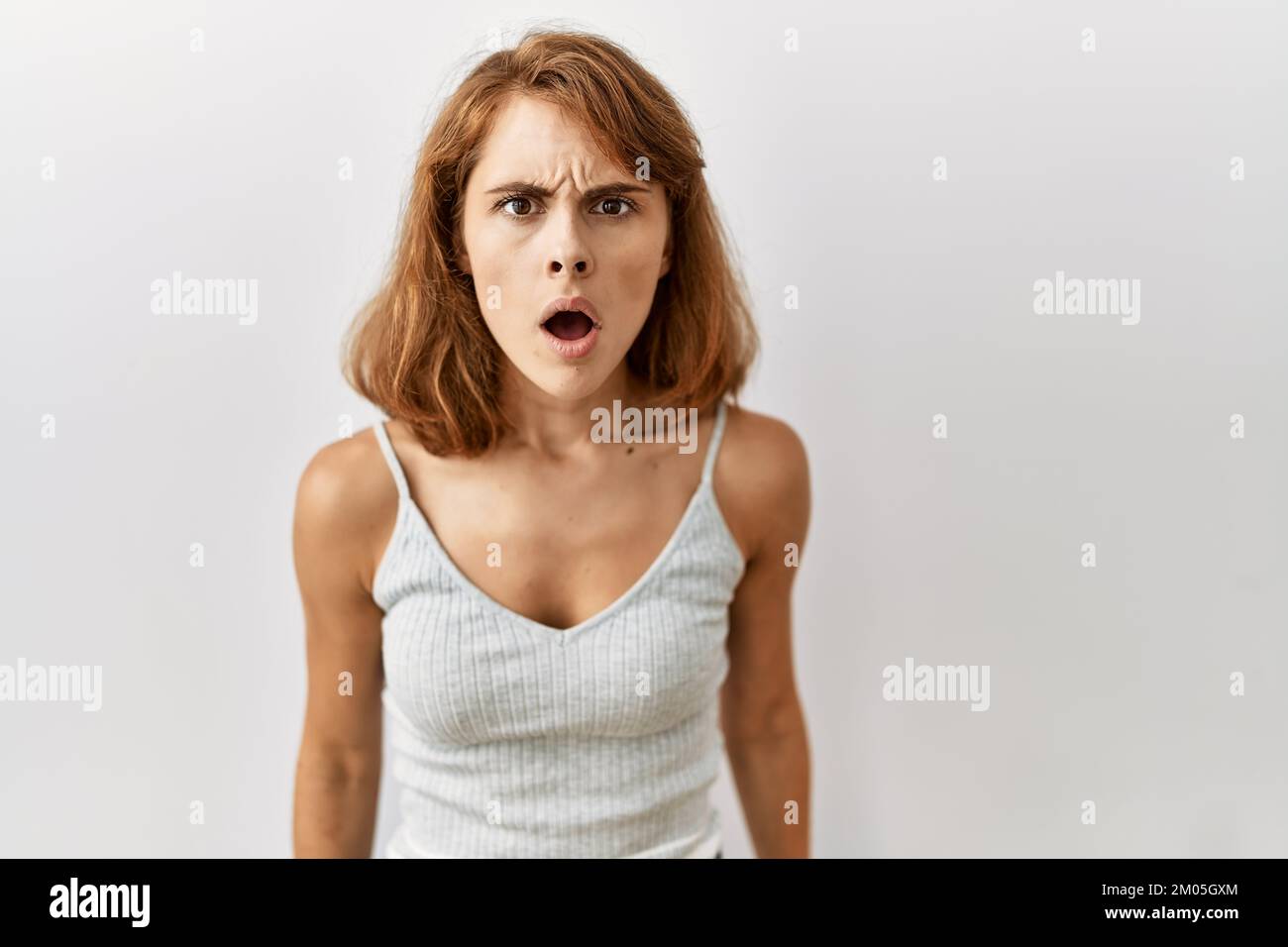 Beautiful caucasian woman standing over isolated background afraid and ...