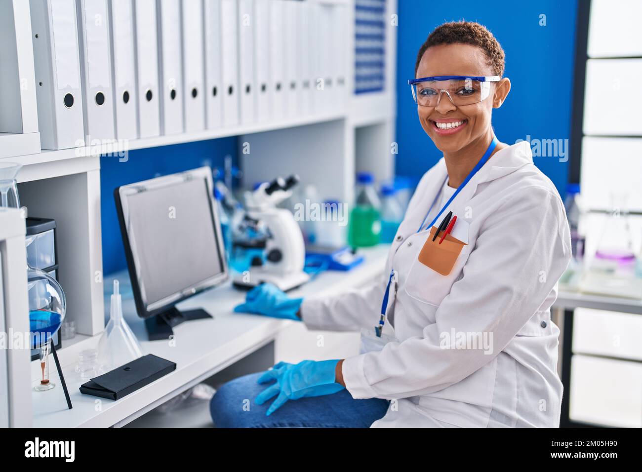 African american woman scientist smiling confident using computer at laboratory Stock Photo - Alamy