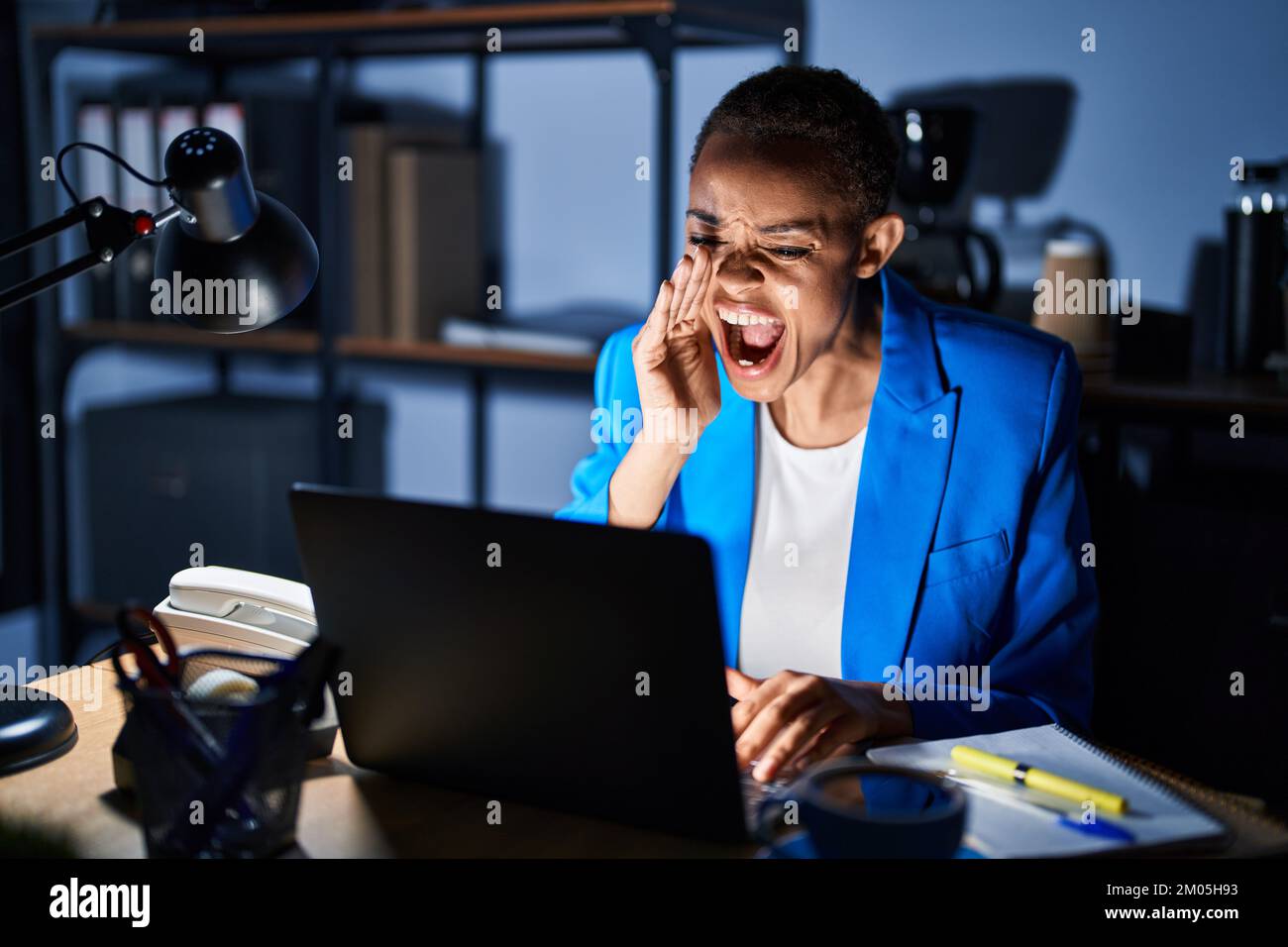 Beautiful african american woman working at the office at night ...