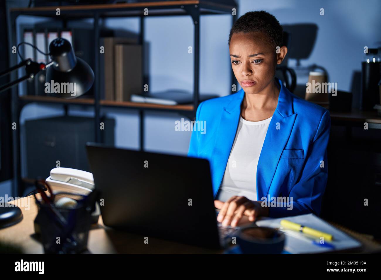Beautiful african american woman working at the office at night ...