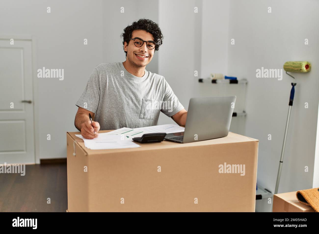 Young hispanic man calculate economy using laptop at new home Stock ...
