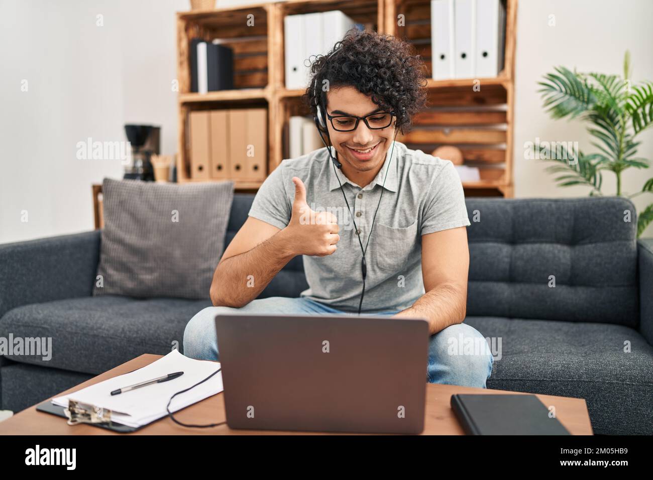Hispanic man with curly hair doing online session at consultation ...