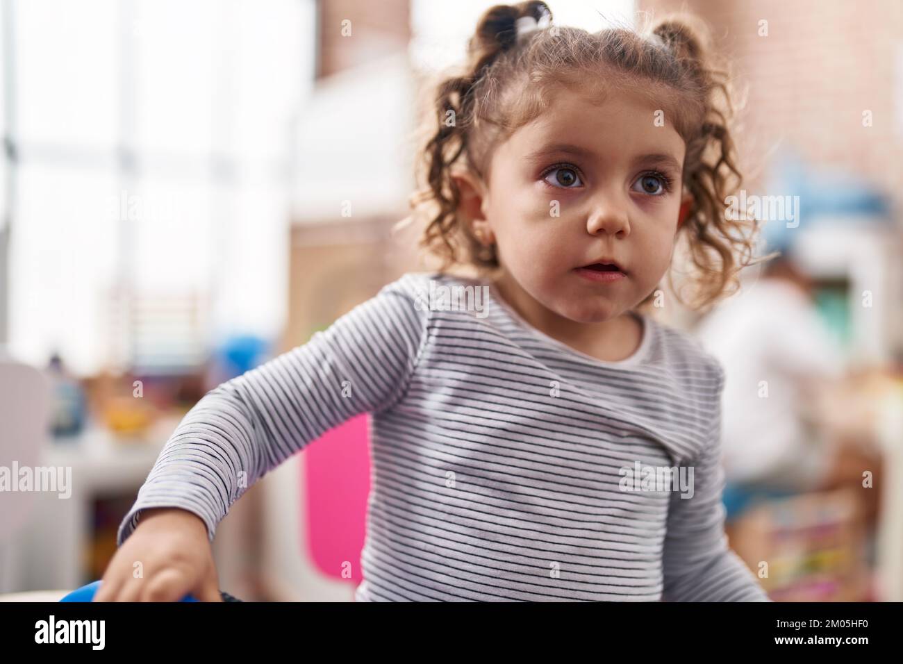Adorable caucasian girl standing with relaxed expression at ...