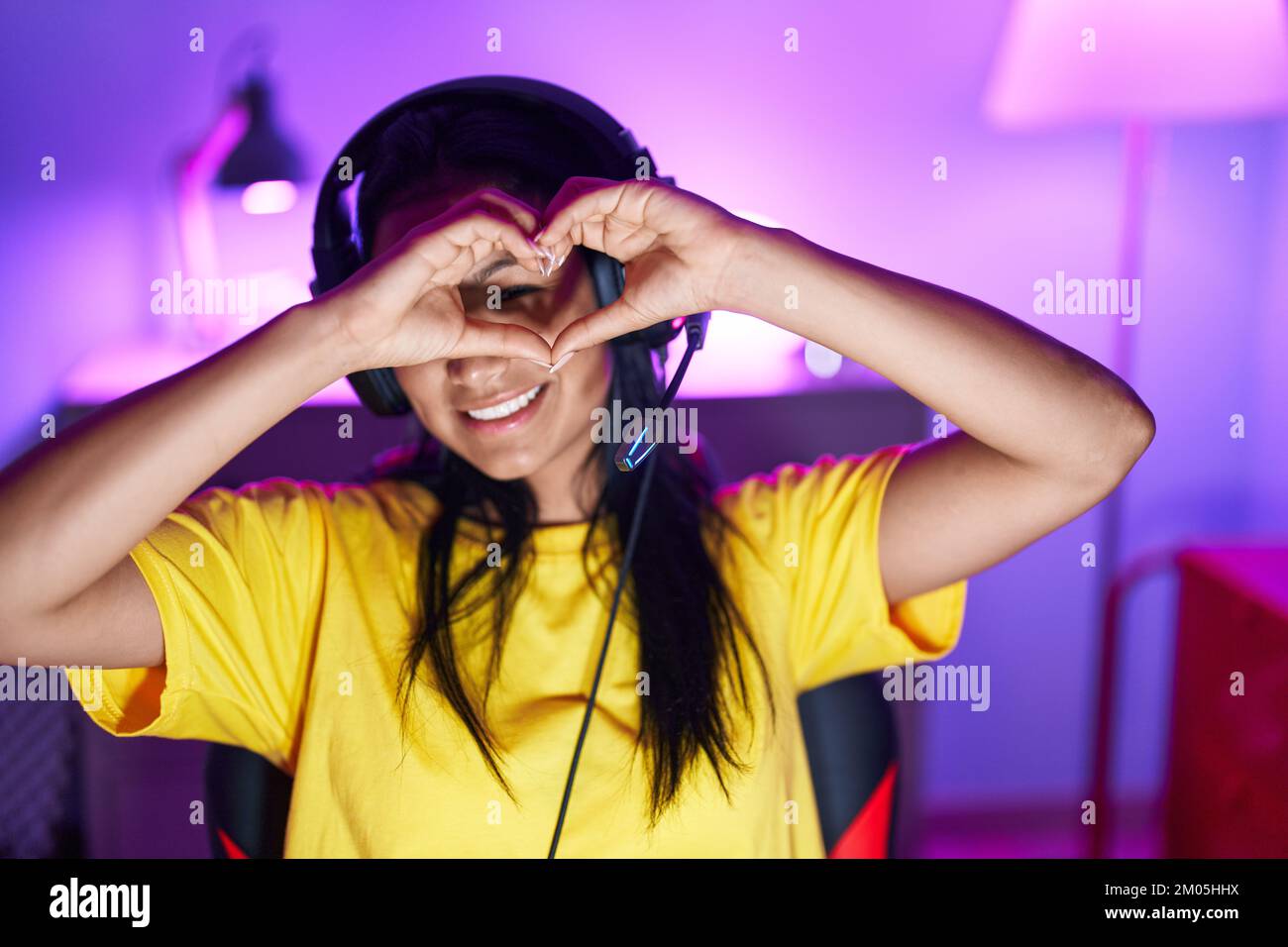 Young beautiful latin woman streamer smiling confident doing heart ...