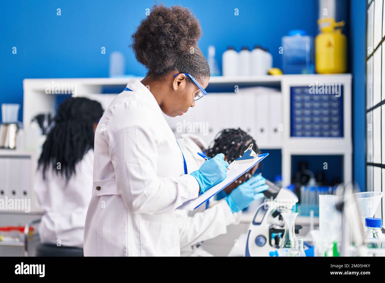 African american friends scientists writing on clipboard working at ...