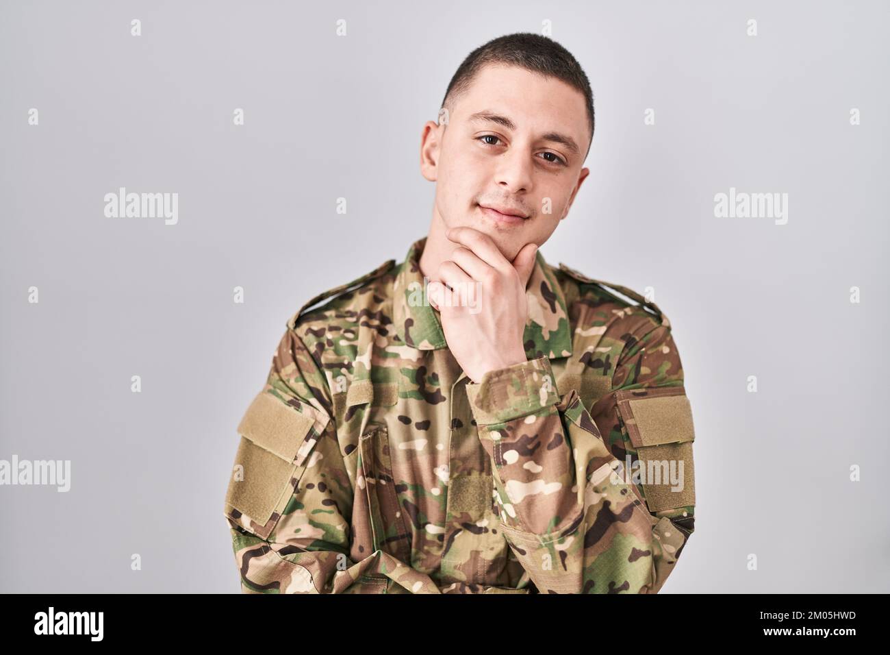 Young man wearing camouflage army uniform looking confident at the ...