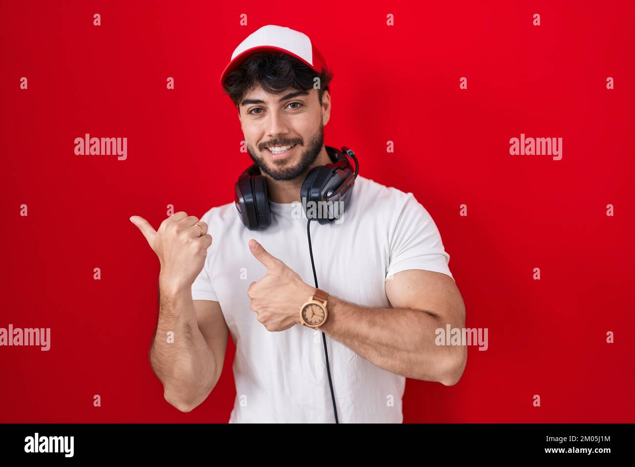 Hispanic man with beard wearing gamer hat and headphones pointing to ...