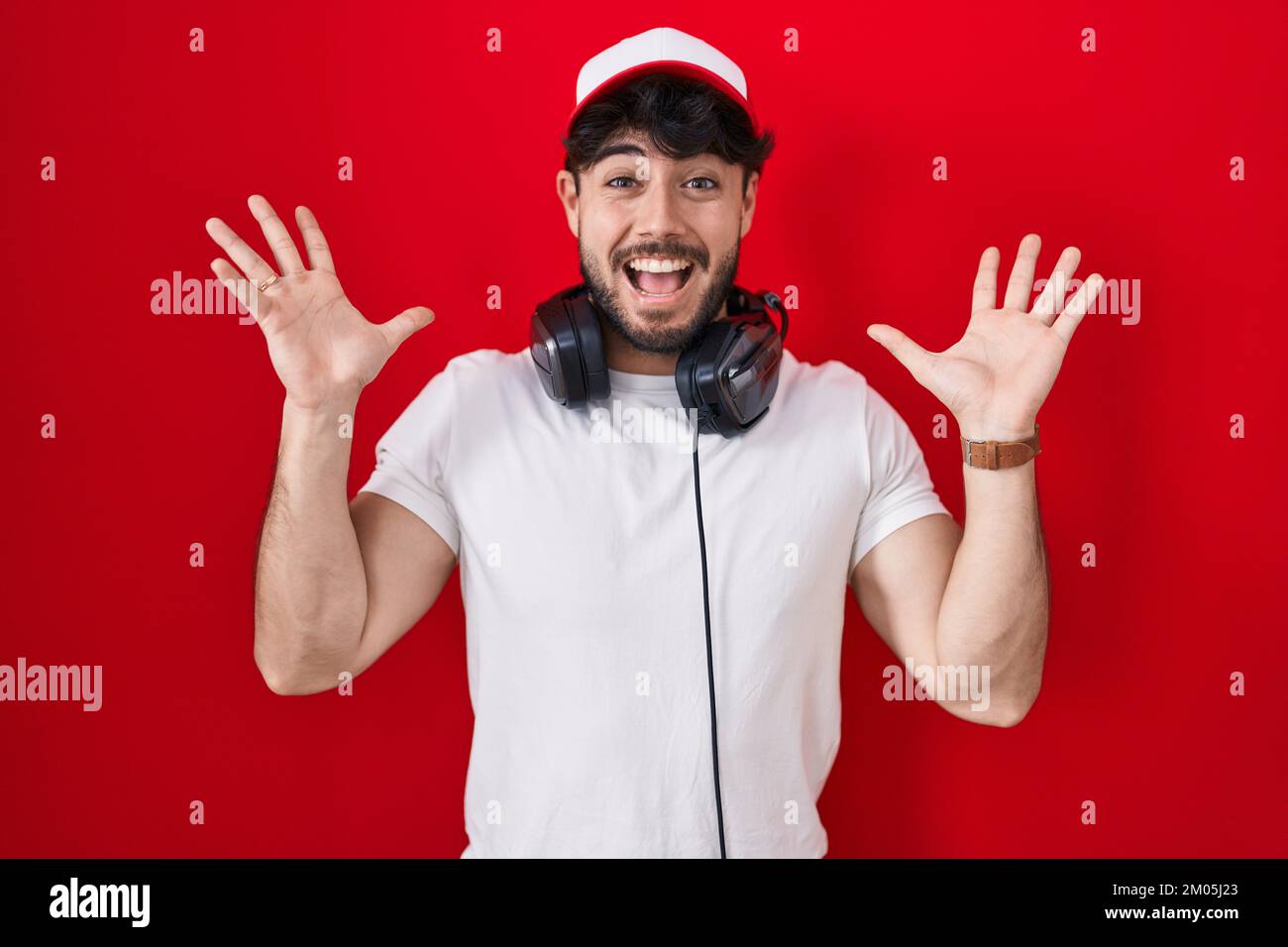 Hispanic man with beard wearing gamer hat and headphones celebrating ...