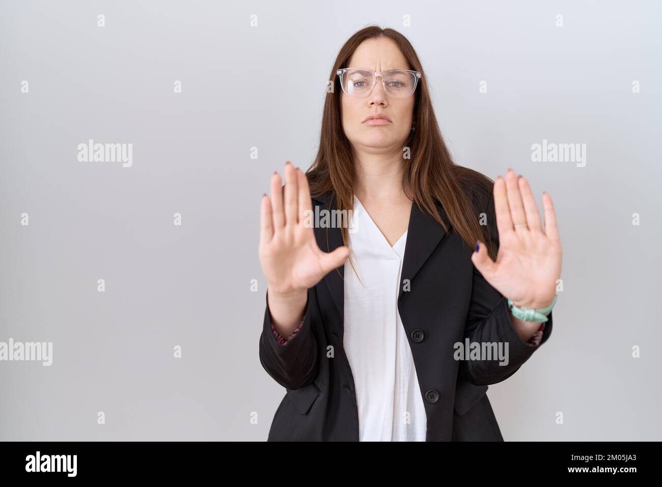 Beautiful brunette woman wearing business jacket and glasses moving ...