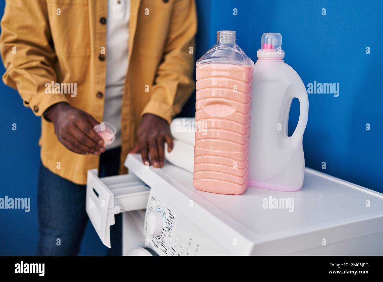 Young african american man smiling confident pouring detergent on ...
