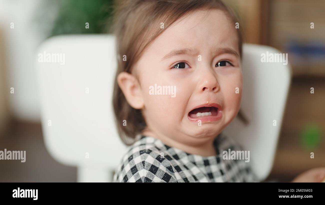 Adorable chinese girl sitting table crying at kindergarten Stock Photo ...