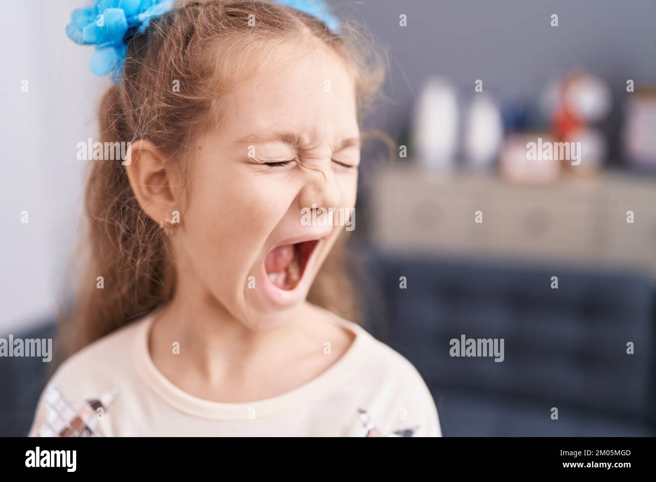 Adorable caucasian girl screaming at home Stock Photo - Alamy