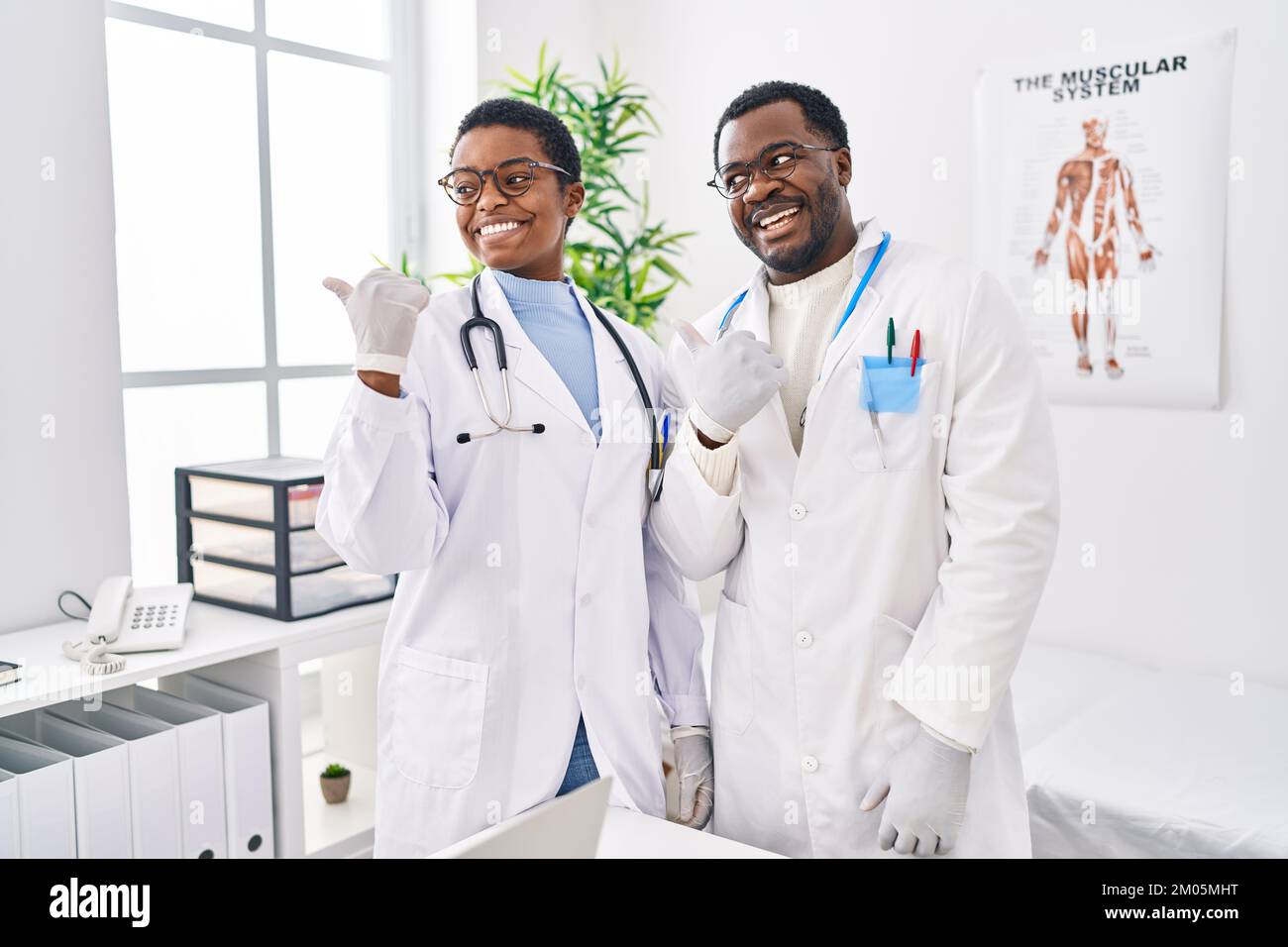 Young african american doctors working at medical clinic smiling with ...