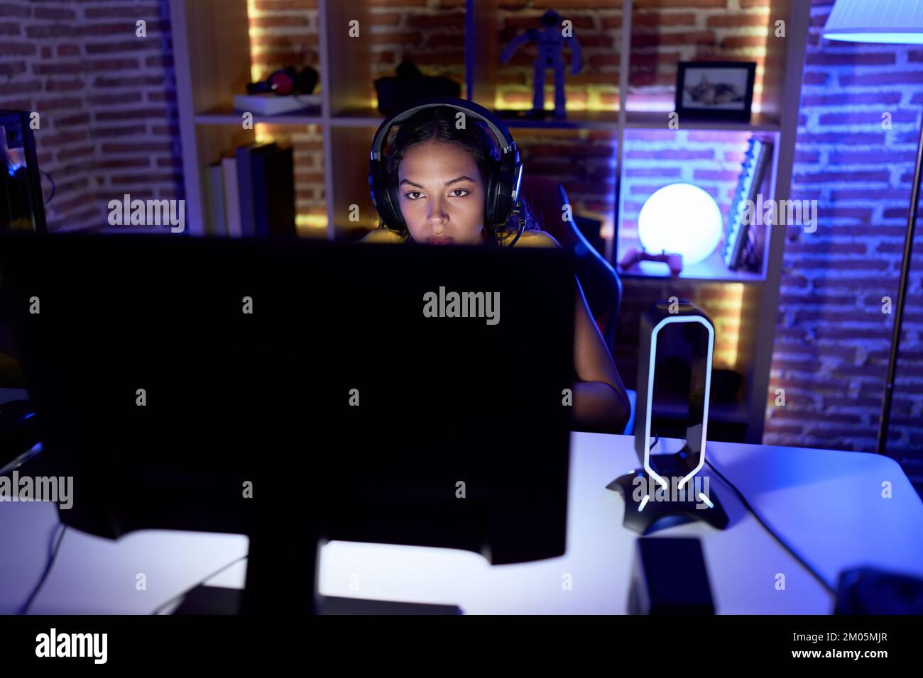 Young african american woman streamer playing video game using computer ...