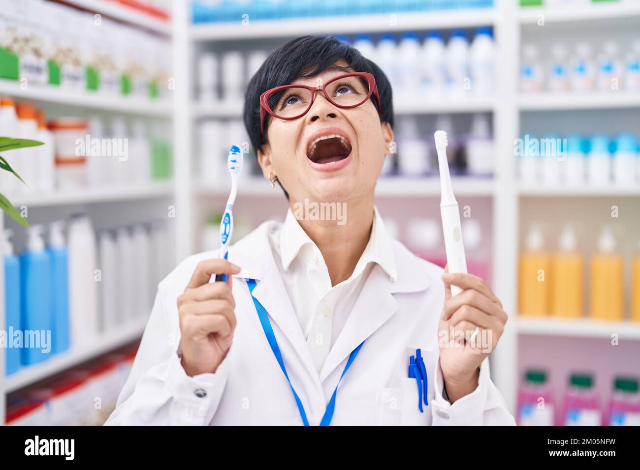 Young asian woman with short hair doing toothbrush comparative at ...