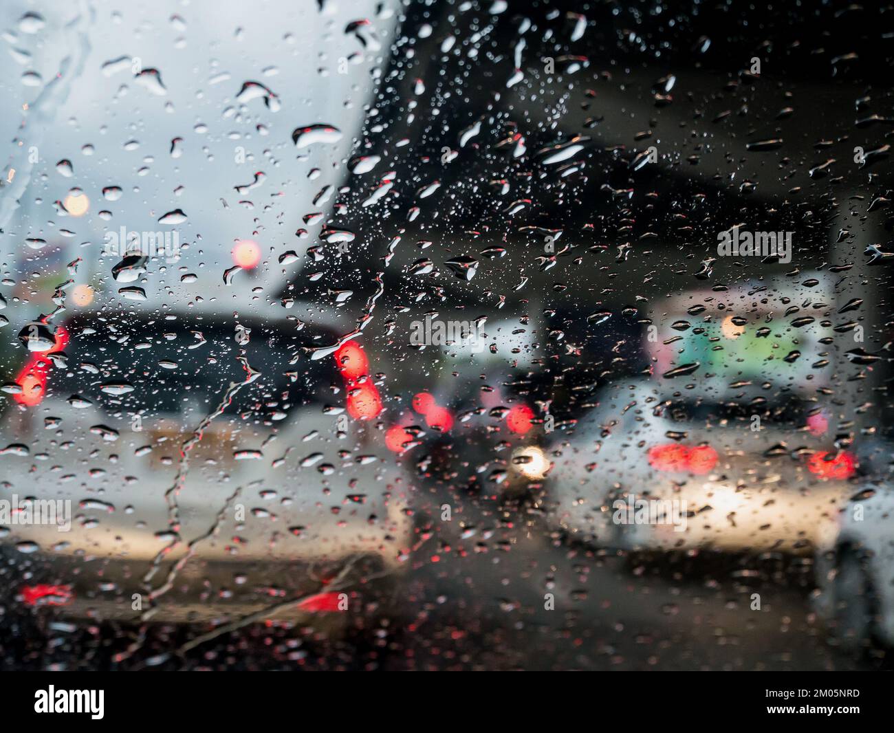 Traffic in rainy day with road view through car window with rain drops ...