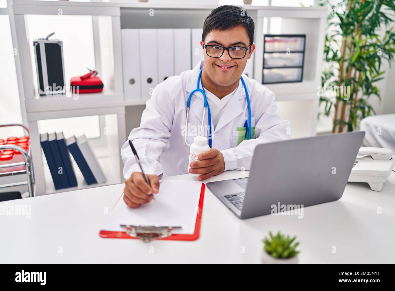 Down syndrome man wearing doctor uniform prescribe pills at clinic ...