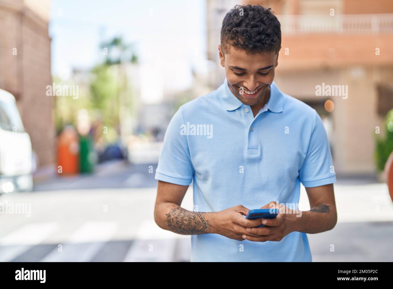 African american man smiling confident using smartphone at street Stock ...