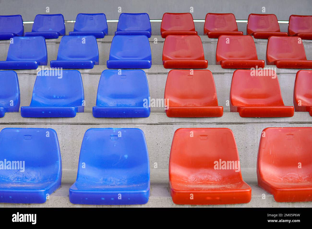 Symmetry tier of empty blue and red seats on a soccer field. Seats in ...